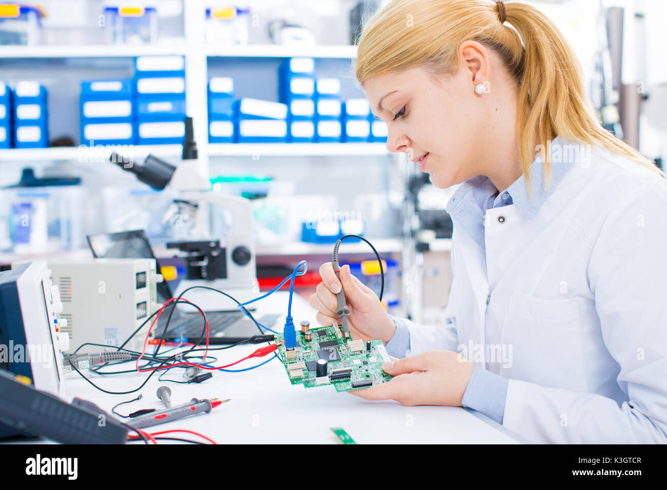 Female laboratory assistant Repairs PCB module for CNC robotics ...