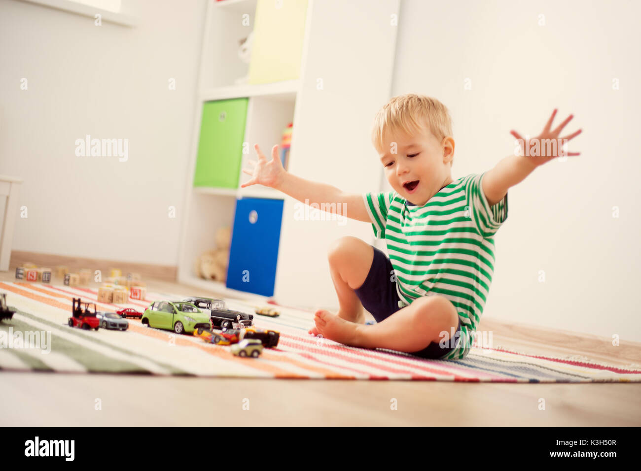 Little child playing with toy cars Stock Photo - Alamy
