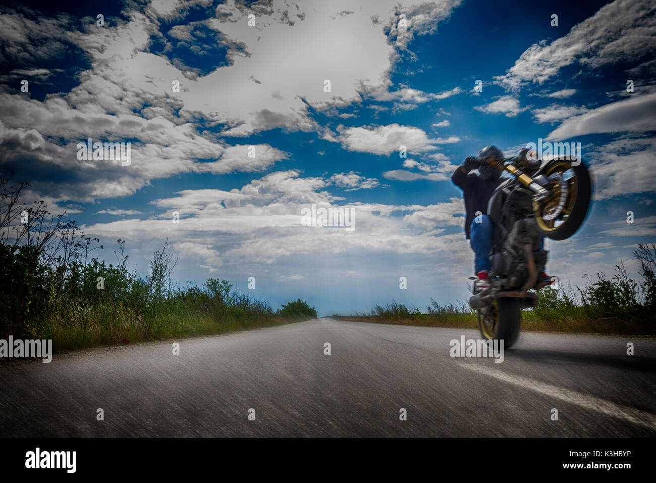 Riding Bike on one wheel on Asphal Road Stock Photo - Alamy