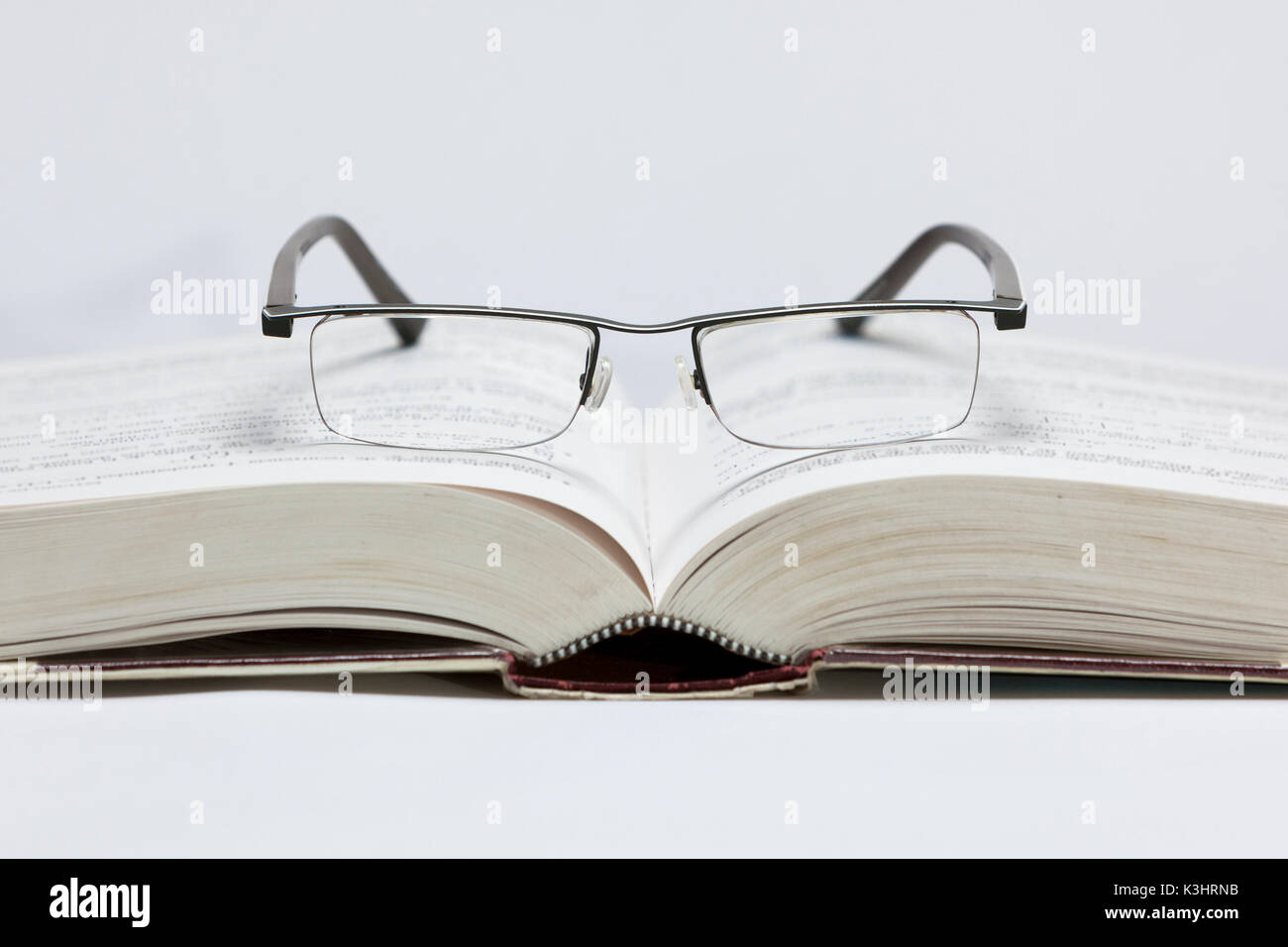 Reading glasses on an opened book Stock Photo - Alamy