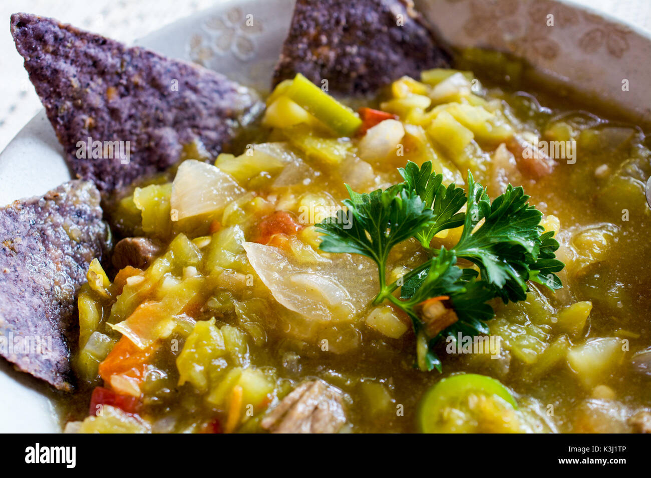 Closeup on Mexican chili pepper stew in tan bowl decorated with blue ...