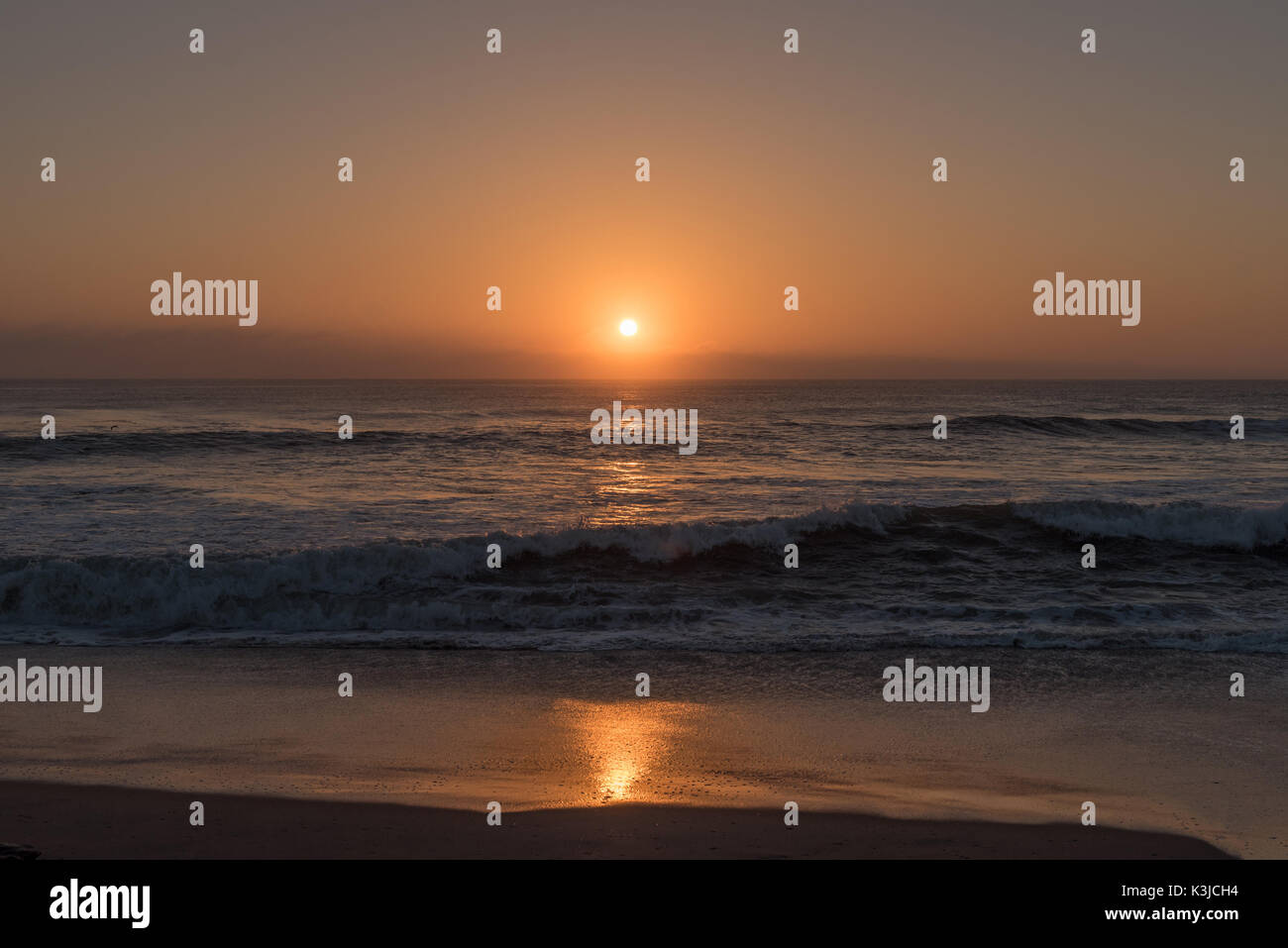 The sun sets over the Atlantic Ocean at Cape Cross on the Skeleton ...