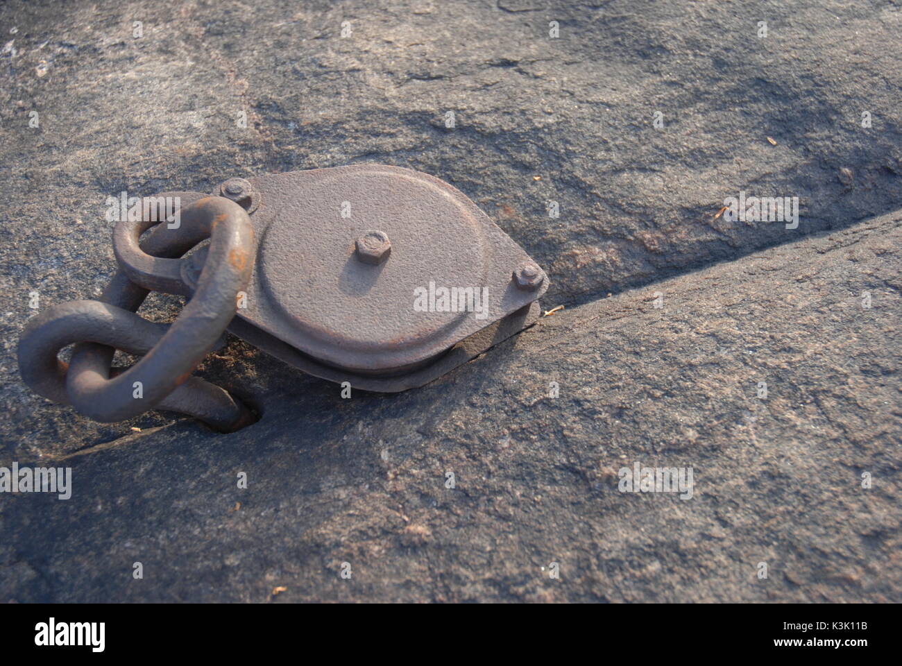 Rusty pulley anchored in a rock Stock Photo - Alamy