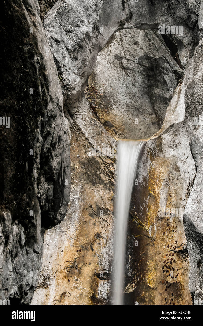 A small watercourse has worked a hole by the rock Stock Photo - Alamy