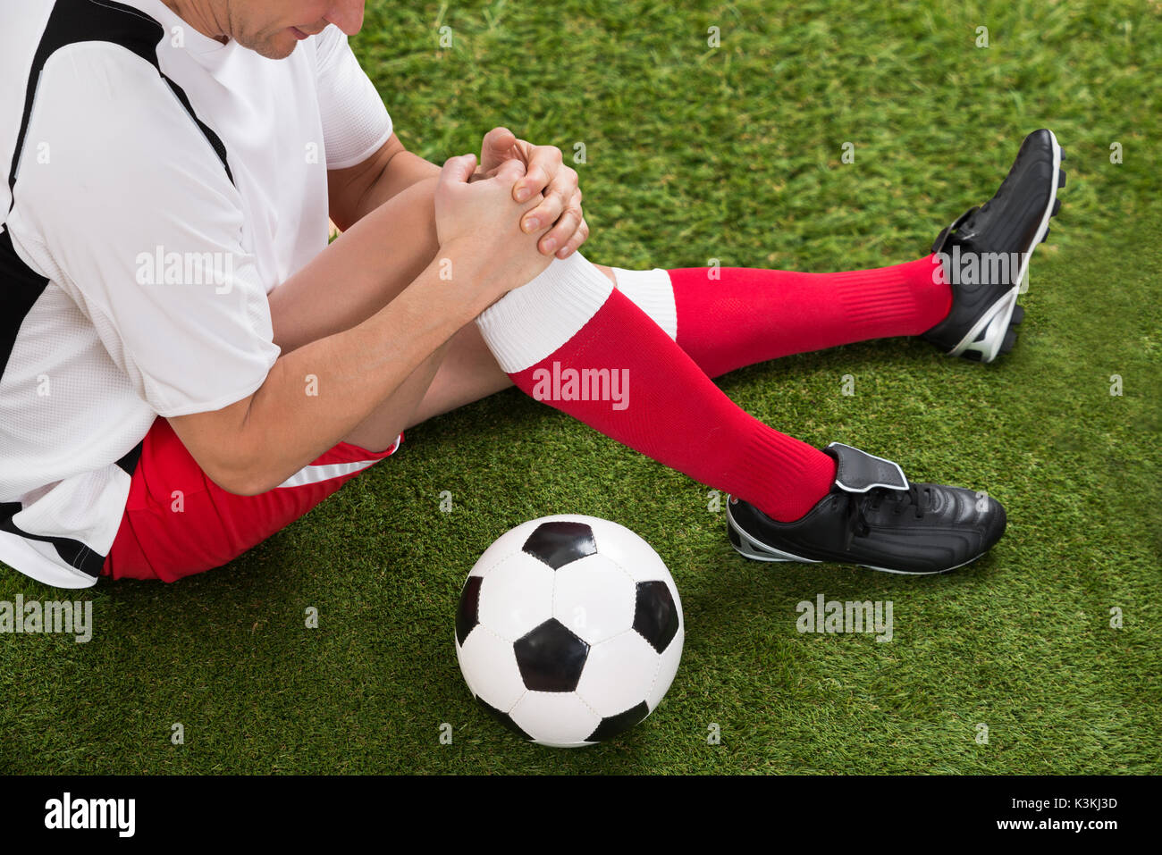 Male Soccer Player Suffering From Injury In Knee At Field Stock Photo ...