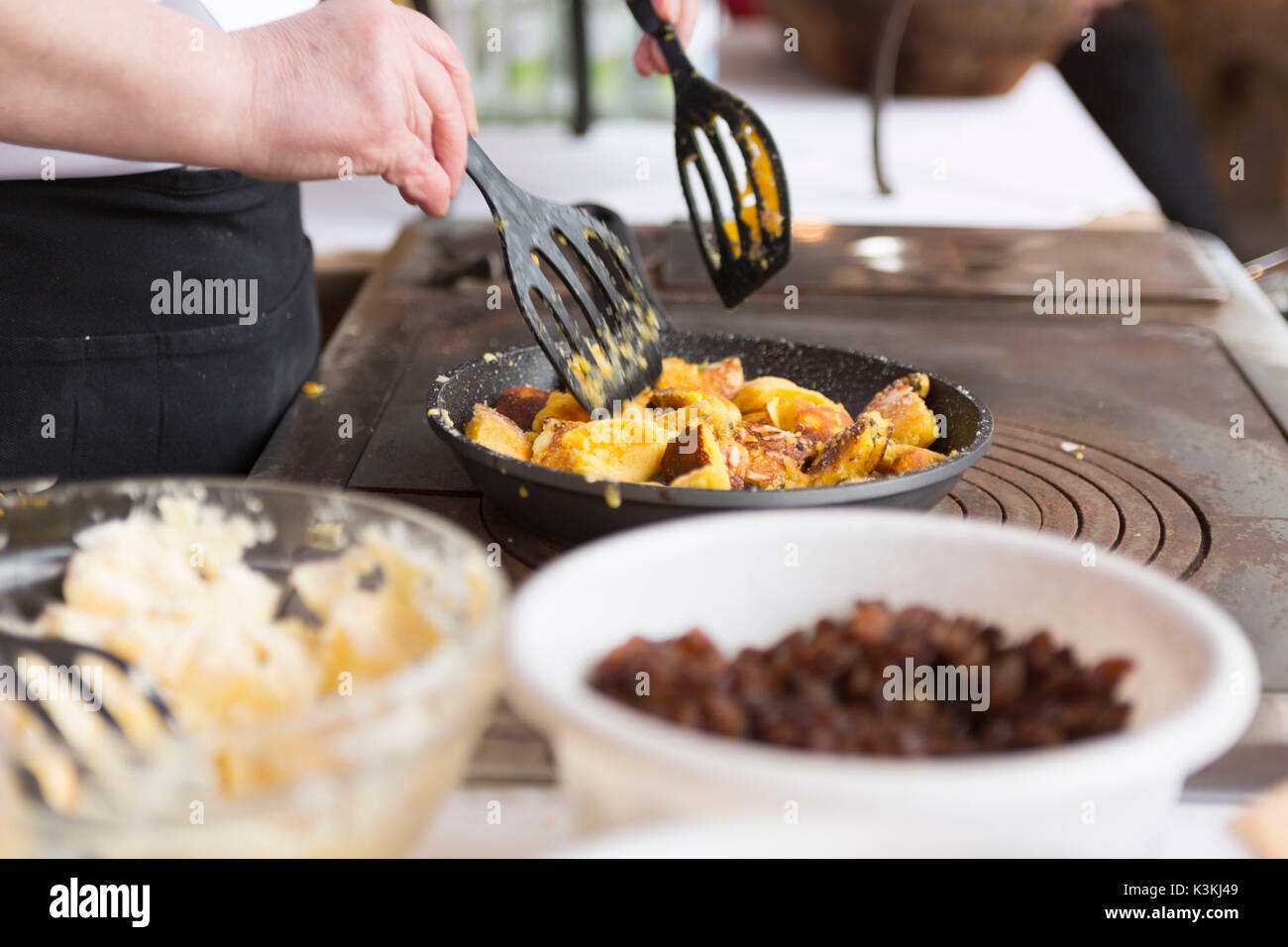 a close up of a cook cooking the Kaiserschmarrn, a typical south ...