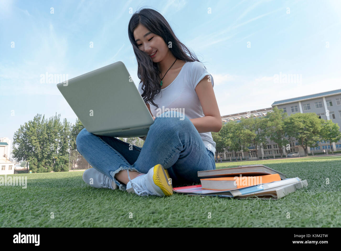 Beautiful Asian college student with laptop ,Sat on the playground ...