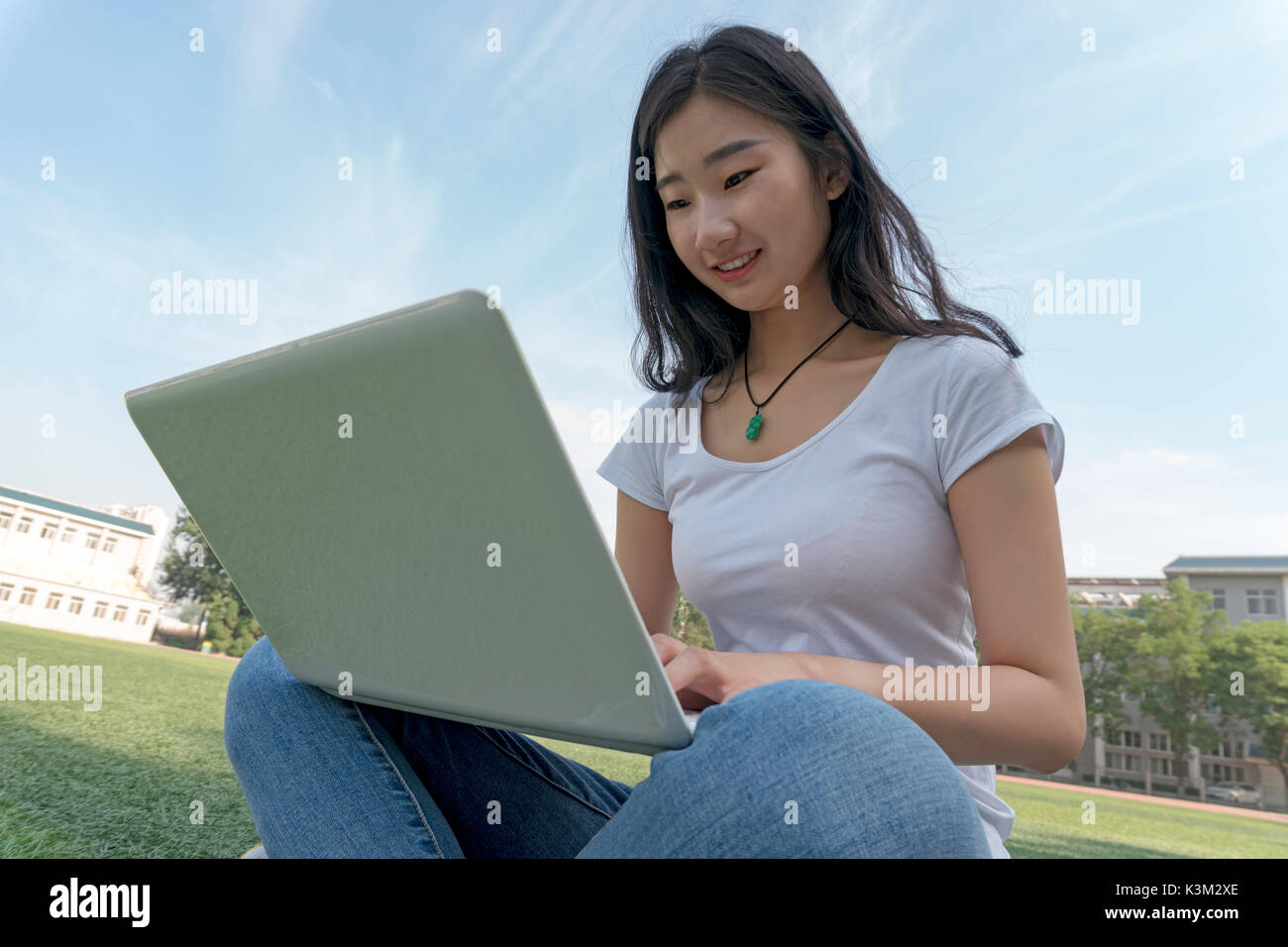 Beautiful Asian college student with laptop ,Sat on the playground ...