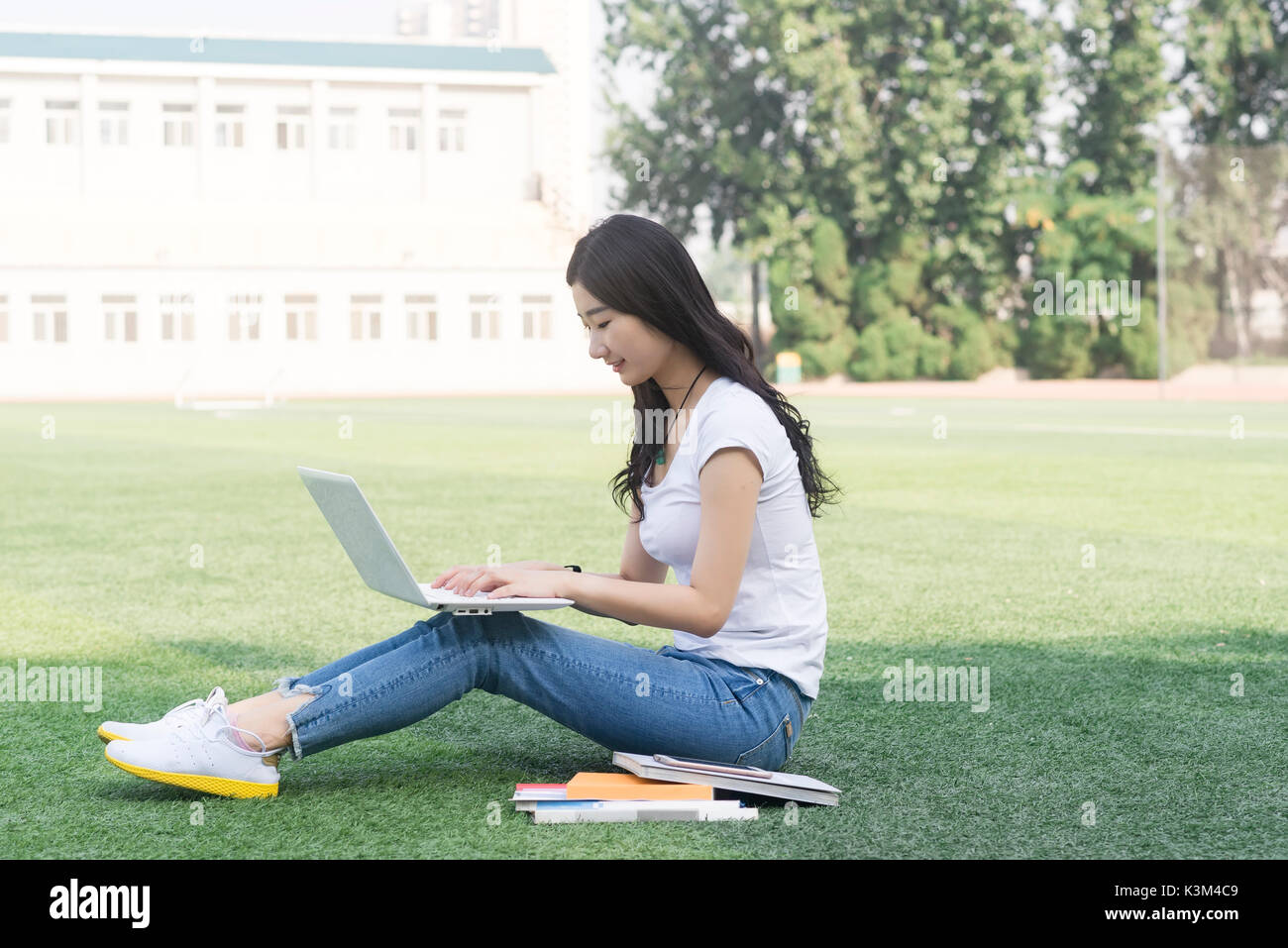 Beautiful Asian college student with laptop ,Sat on the playground ...