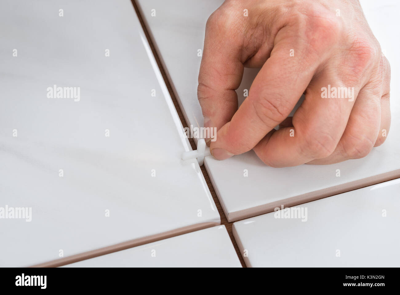 Close-up Of A Person's Hand Placing Spacers Between Ceramic Floor Tiles ...