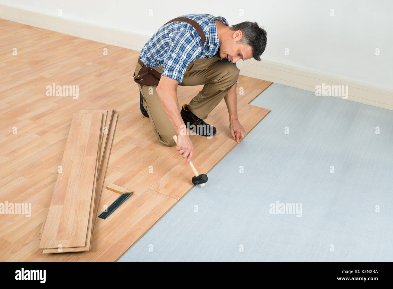 Carpenter Installing New Laminated Wooden Floor At Home Stock Photo - Alamy