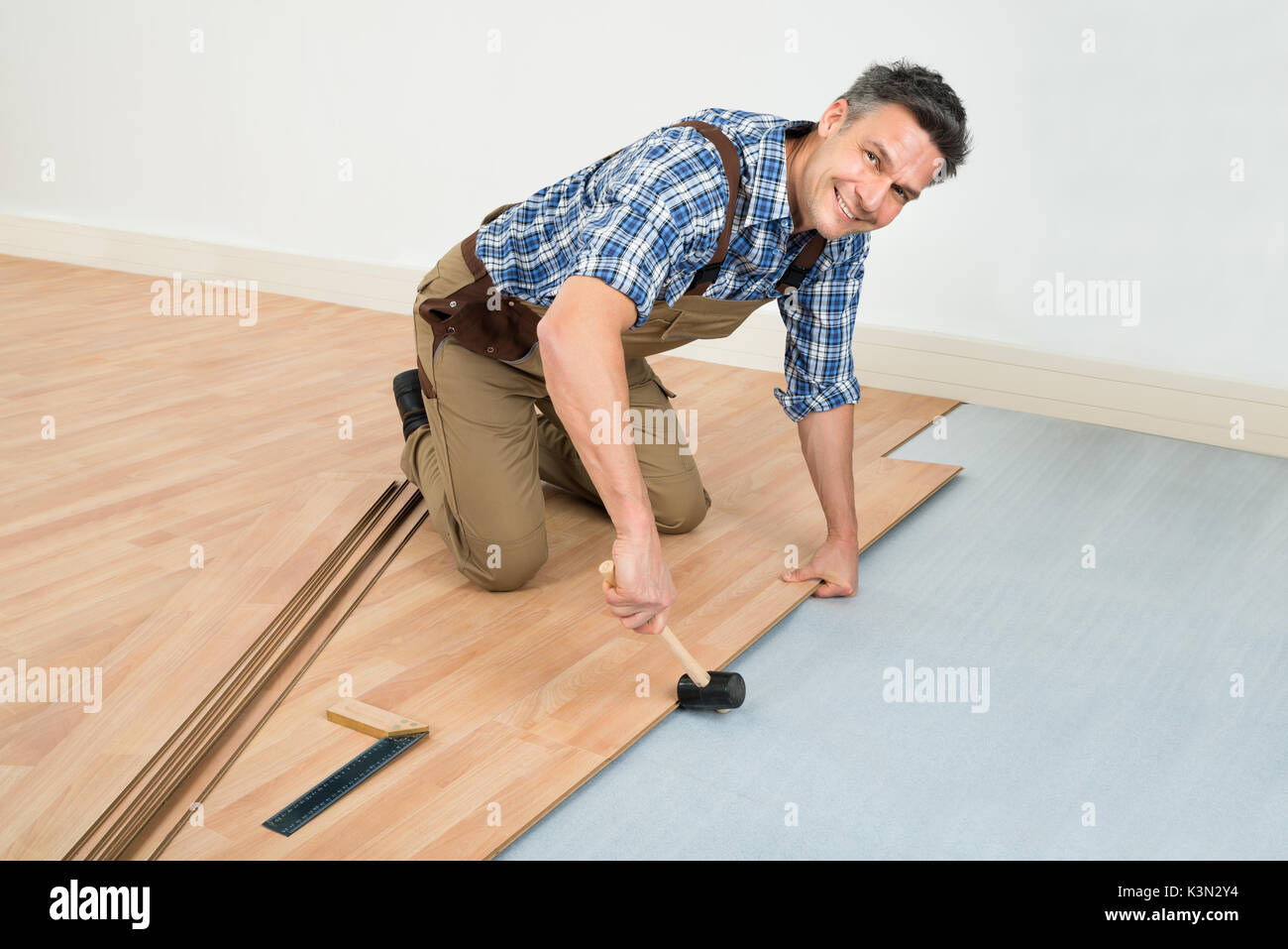Carpenter Installing New Laminated Wooden Floor At Home Stock Photo - Alamy