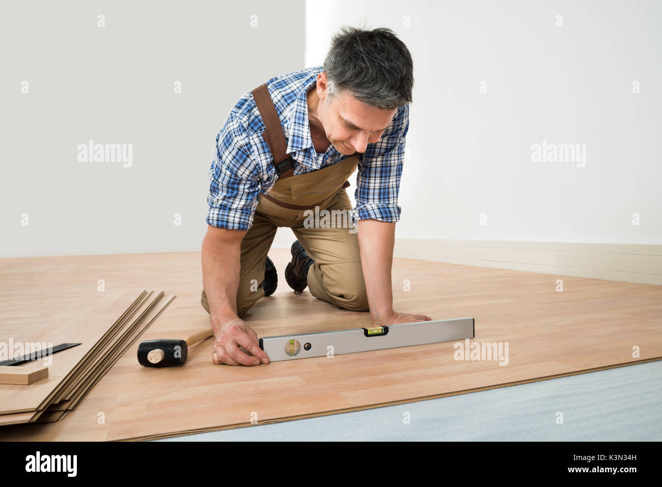 Carpenter Installing New Laminated Wooden Floor At Home Stock Photo - Alamy