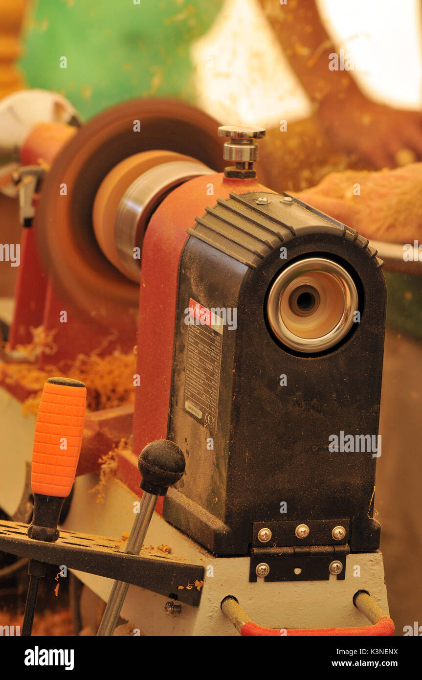 A man using a lathe wood turning carving and using chisels to form and ...