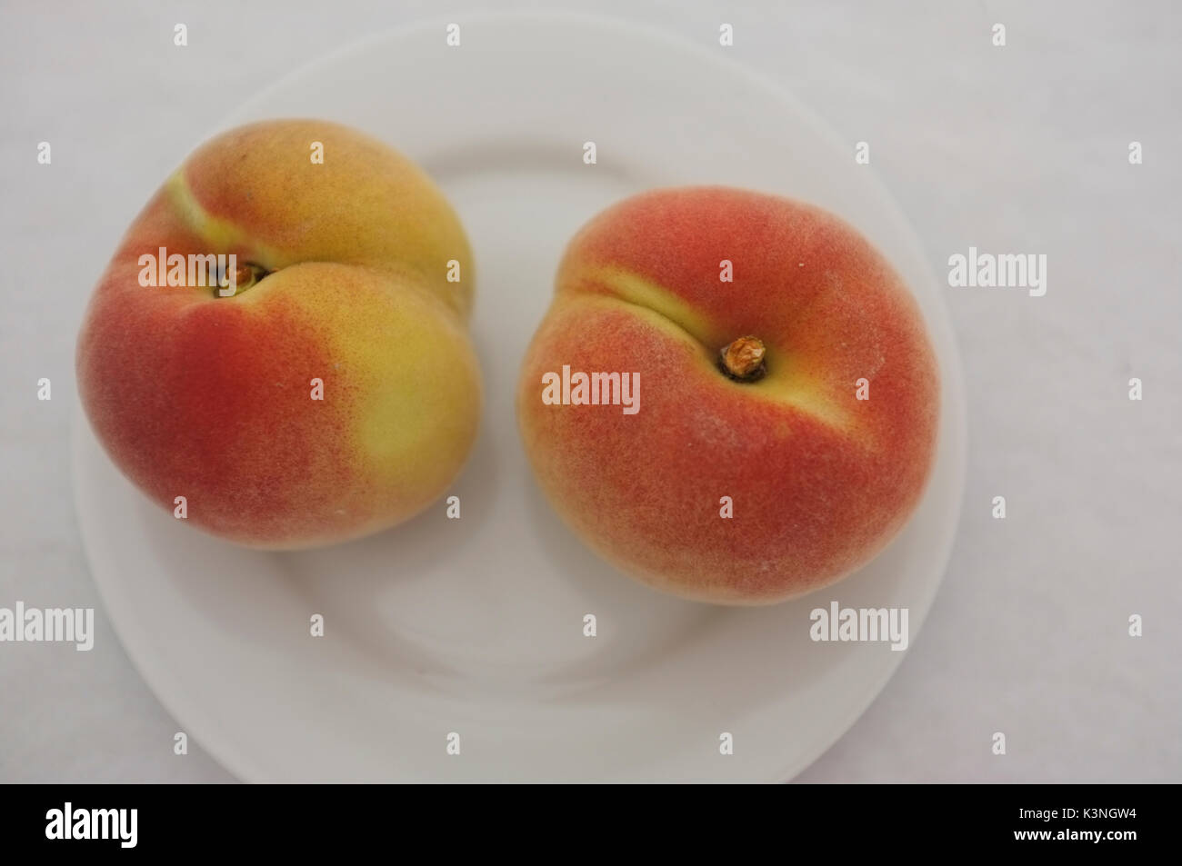 Two Peaches on a Plate Stock Photo - Alamy