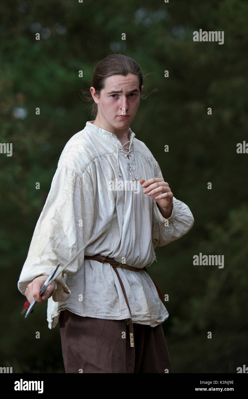Medieval swordsman in wood clearing takes attacking stance Stock Photo ...