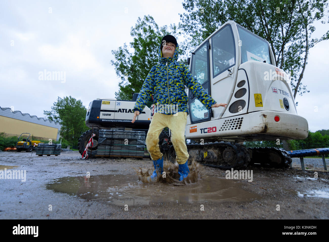 A boy on a rainy day jumps into a puddle Stock Photo - Alamy