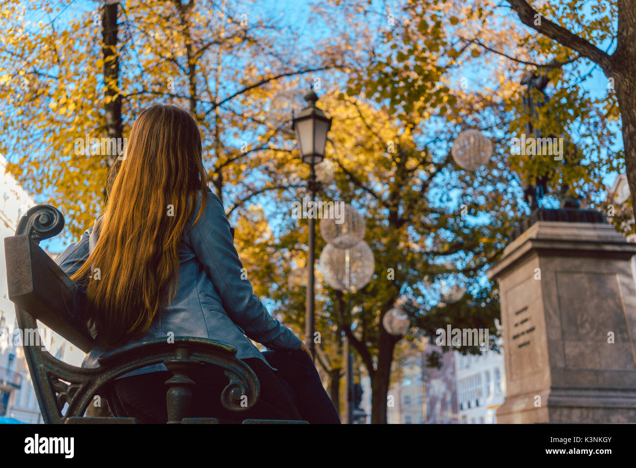 Woman resting on bench after stroll in fall city Stock Photo - Alamy