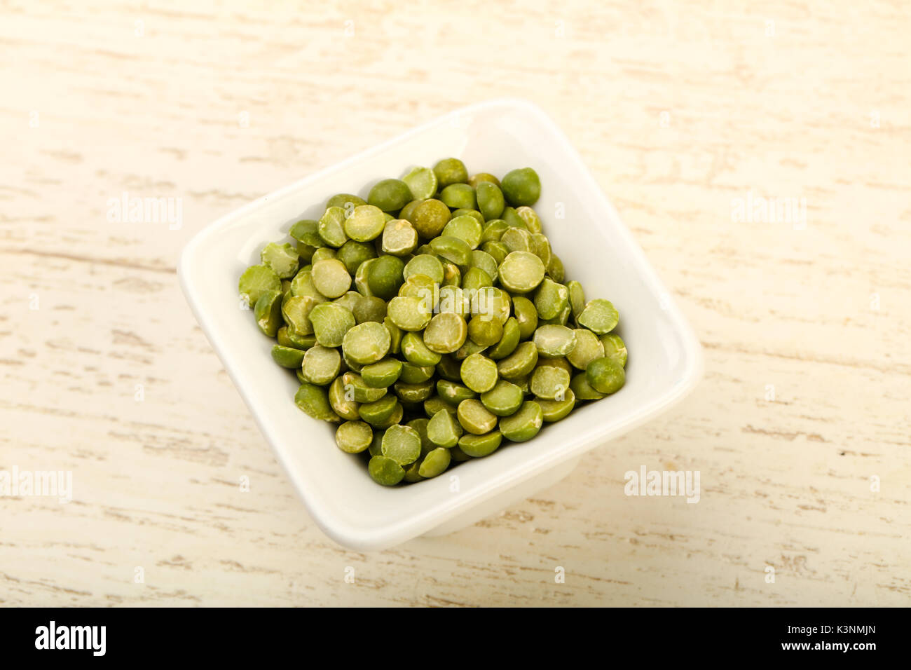 Green peas pile in the bowl over wooden background Stock Photo - Alamy