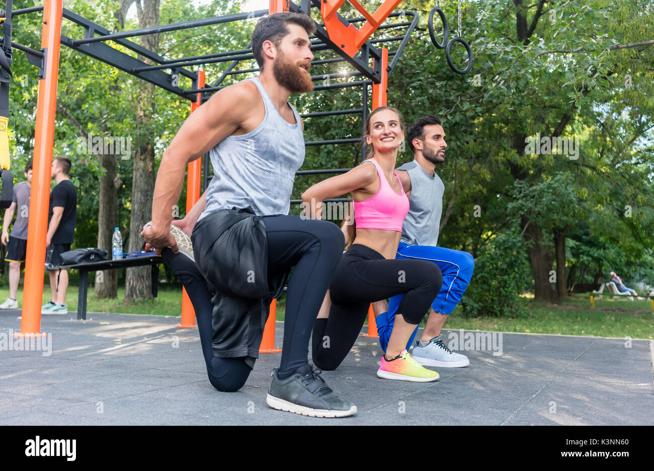 Three determined friends doing stretching exercises for legs as Stock ...