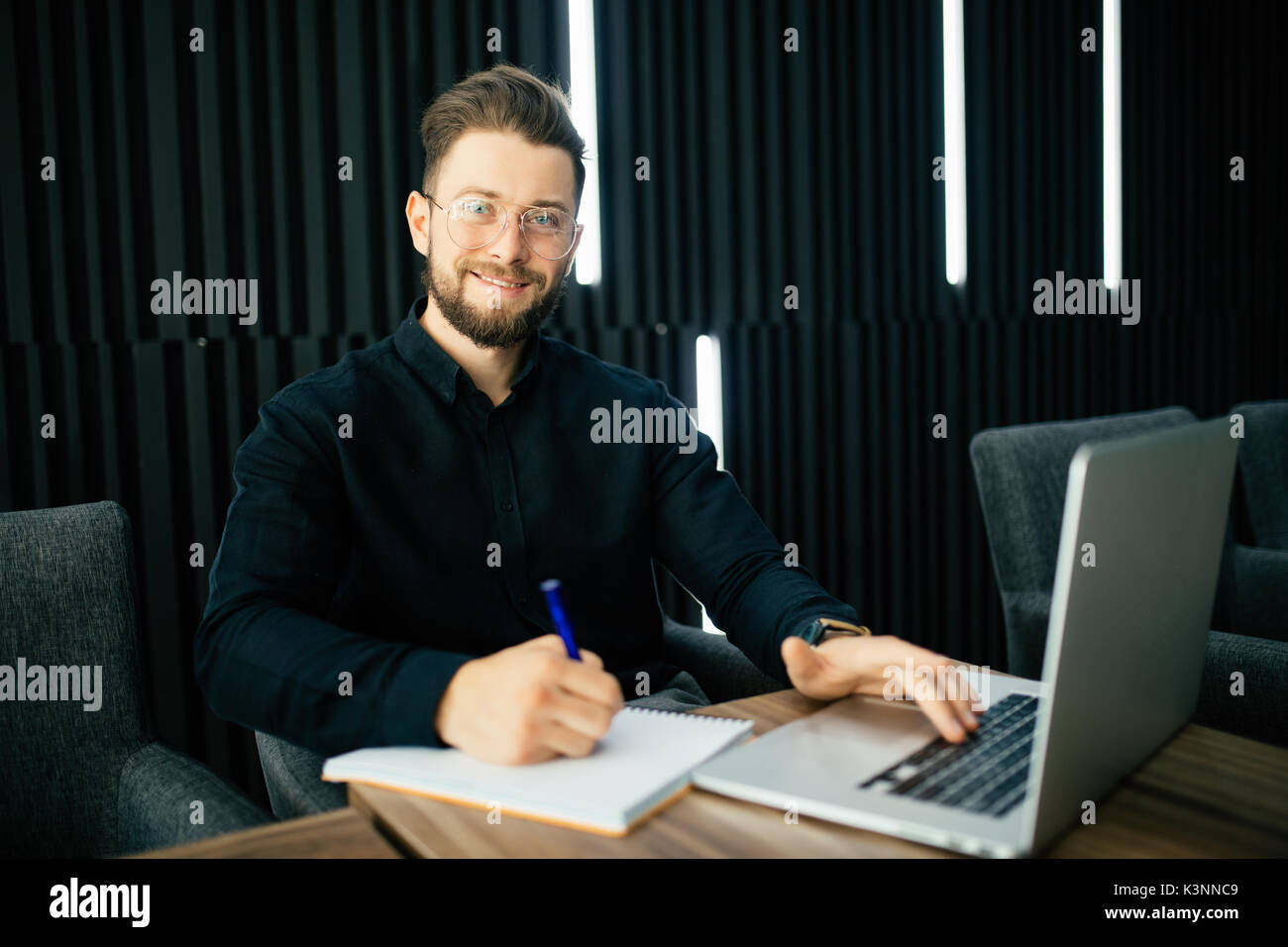 Handsome european boy working on project at modern office desk Stock ...