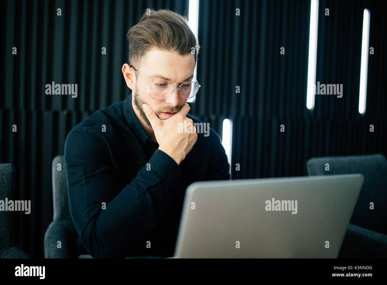 Shot of young man sitting at table looking away and thinking ...