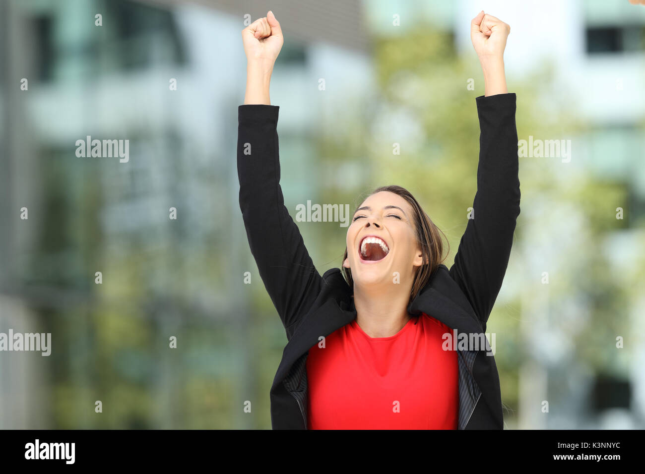Single excited executive raising arms after success on the street Stock ...