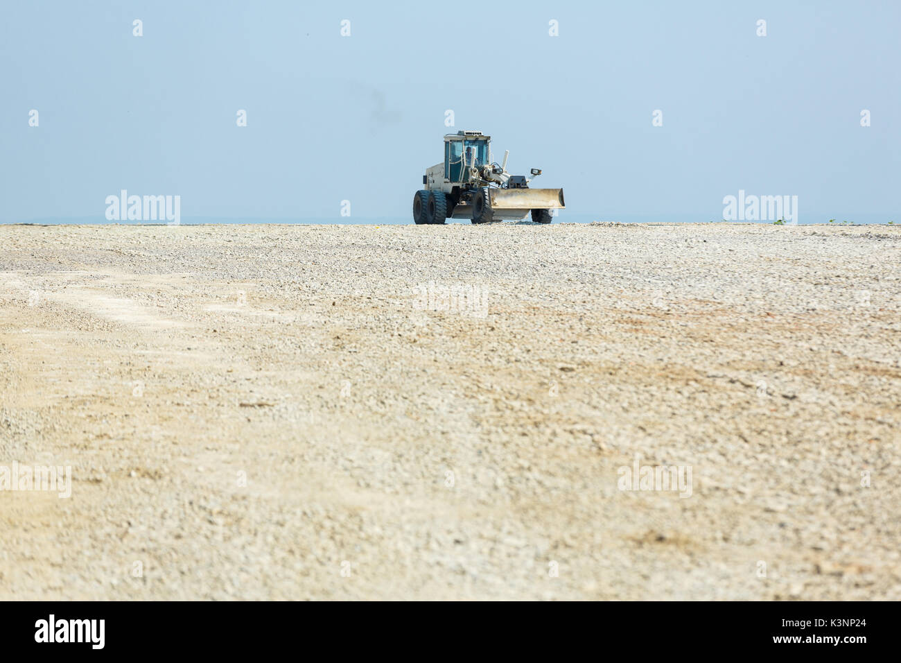 Industrial tractor grading surface prepearing it for further ...