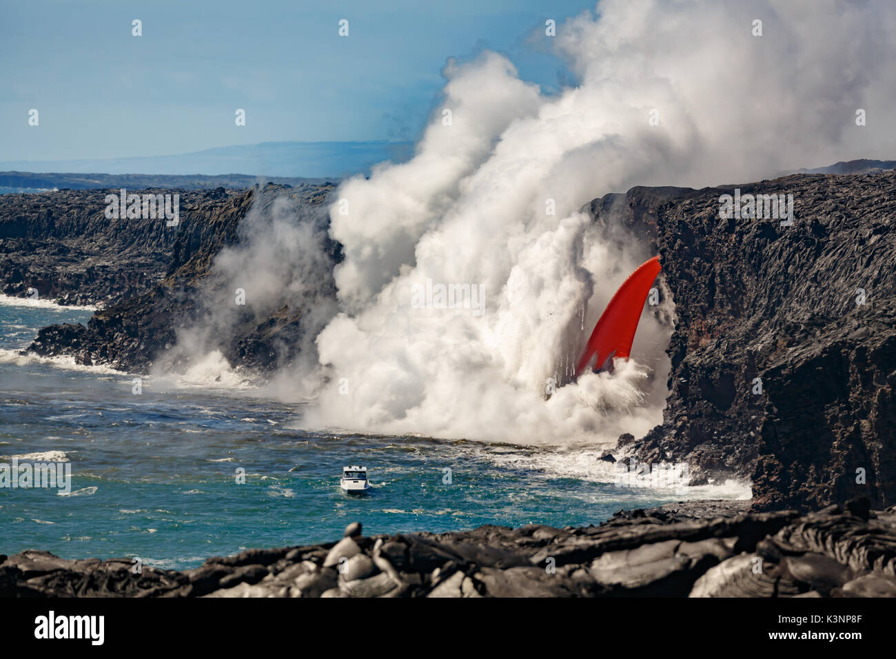 Aerial daytime view of top portion of waterfall shaped flow of red lava ...