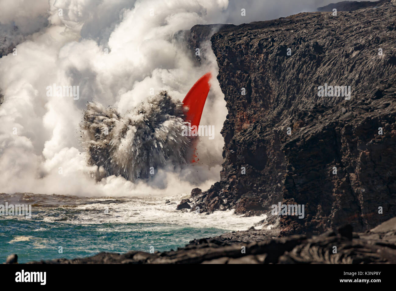 Aerial daytime view of top portion of waterfall shaped flow of red lava ...