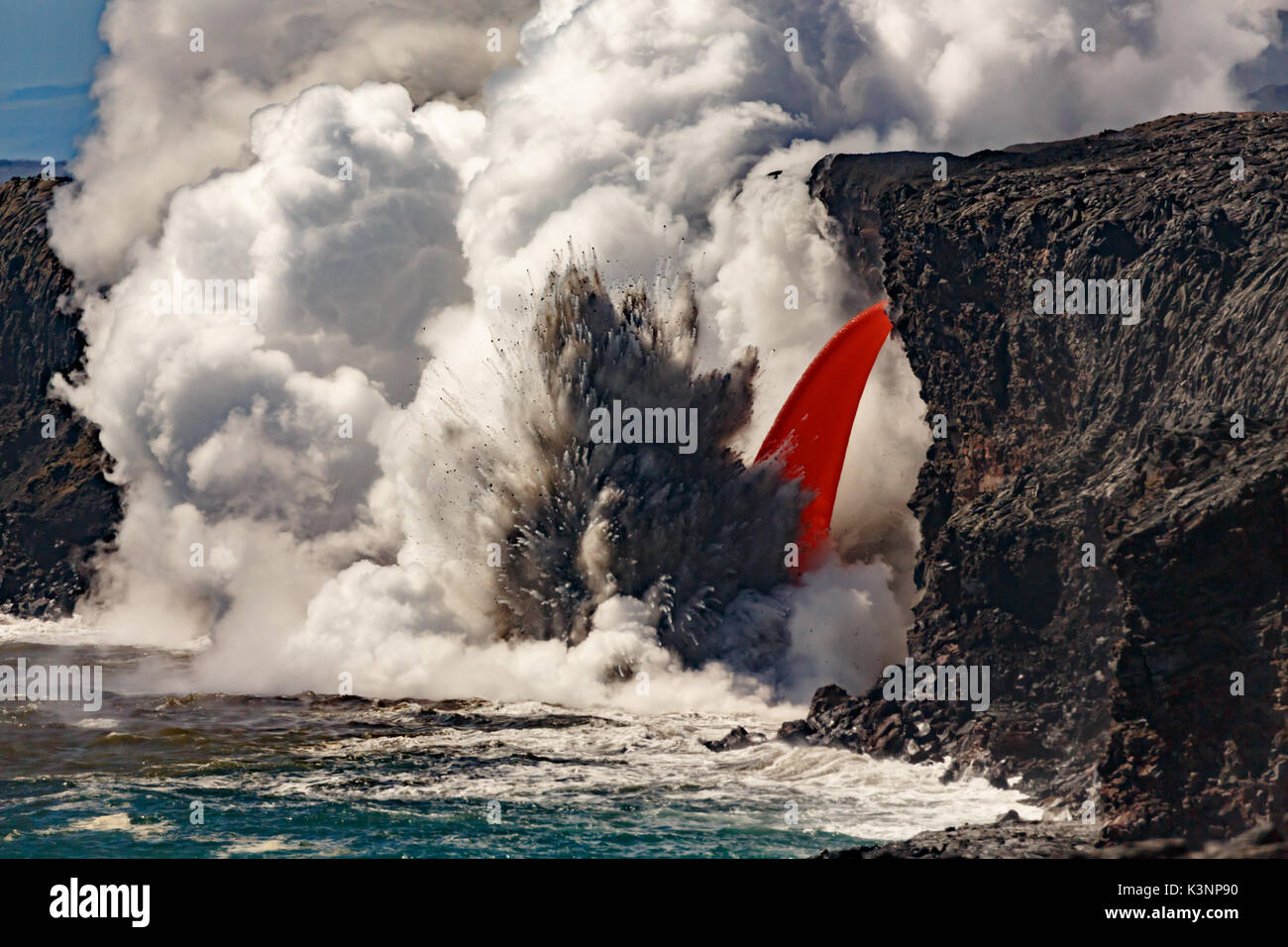 Aerial daytime view of top of waterfall shaped flow of red lava from ...