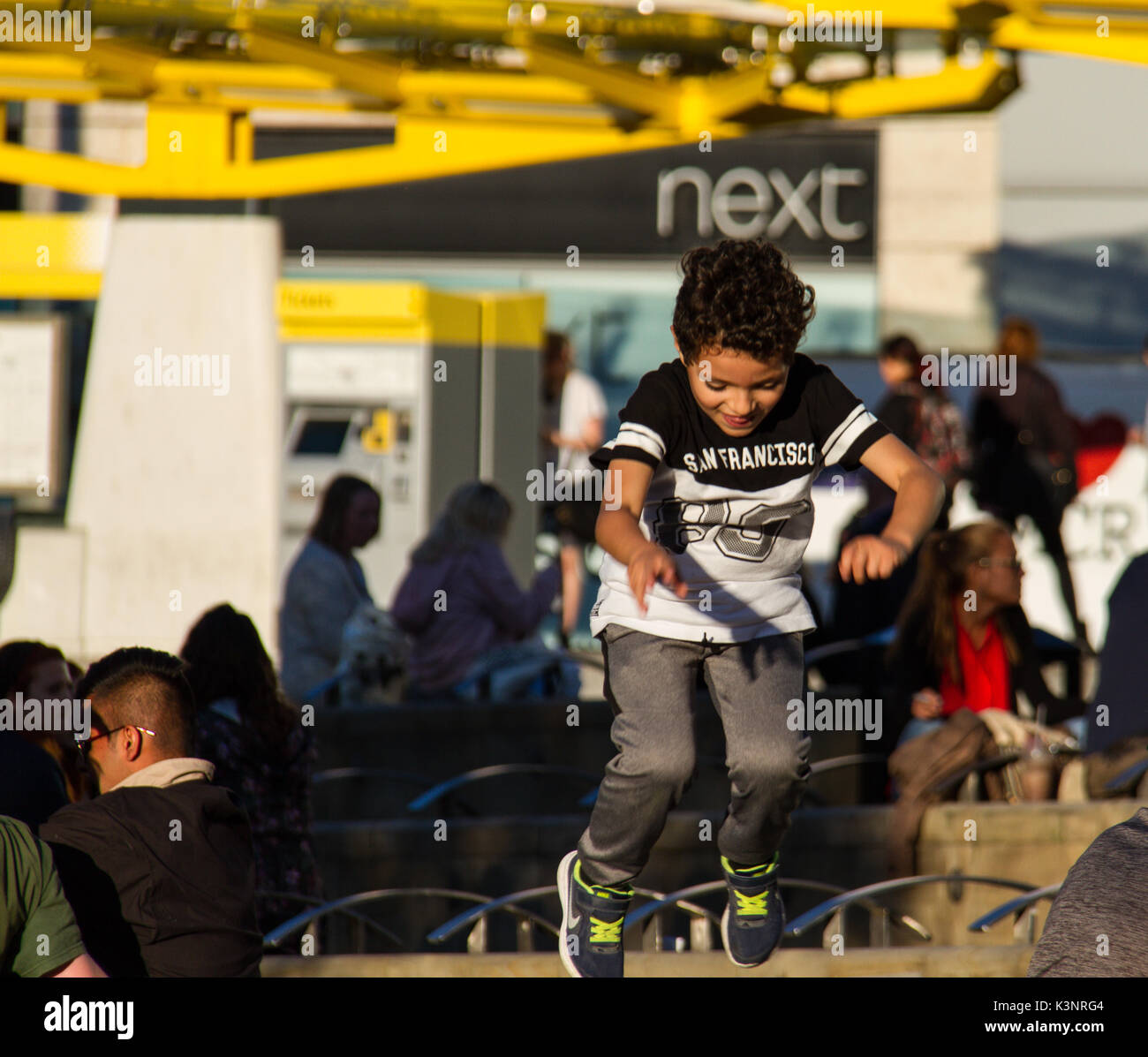 Manchester, United Kingdom - 15 August, 2017: Boy jumping off a bench ...