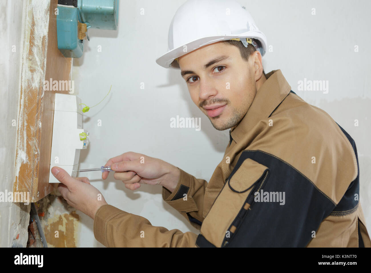 young electrician builder engineer installing a fuse box Stock Photo ...