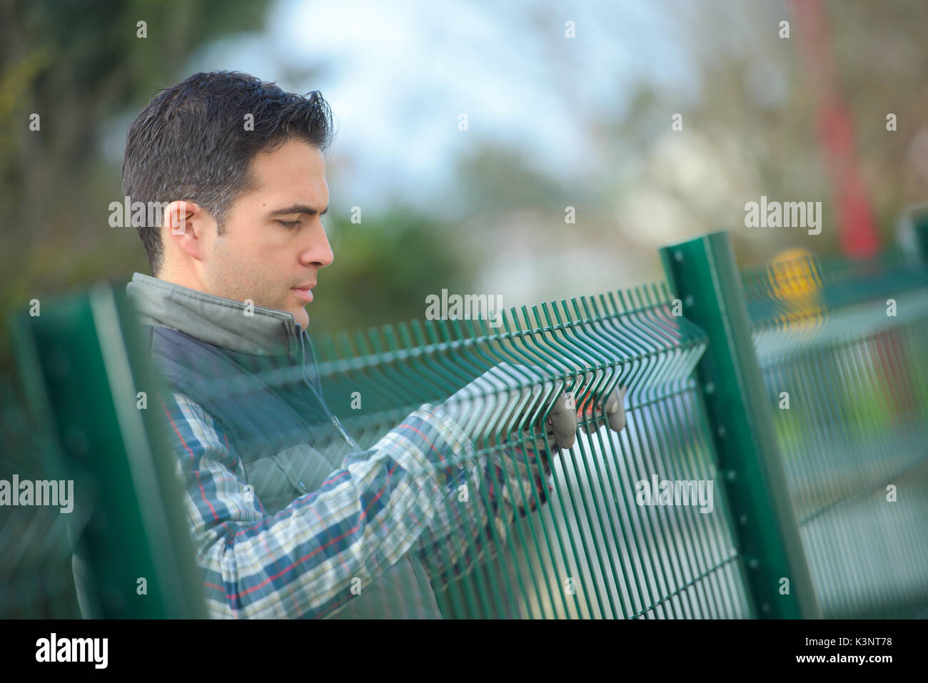 worker putting up a garden fence Stock Photo - Alamy
