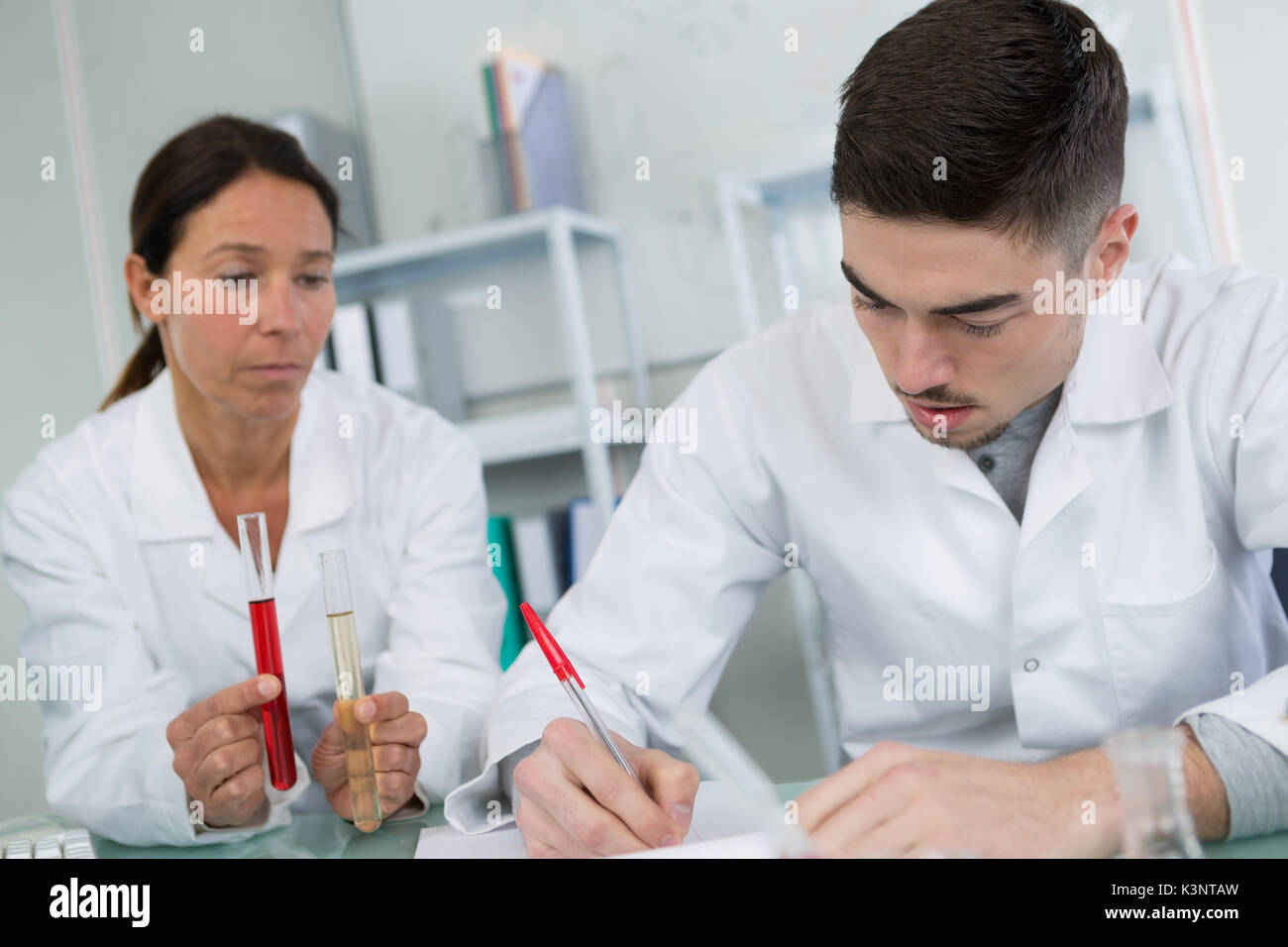 worker holding blood sample and co-worker checking Stock Photo - Alamy