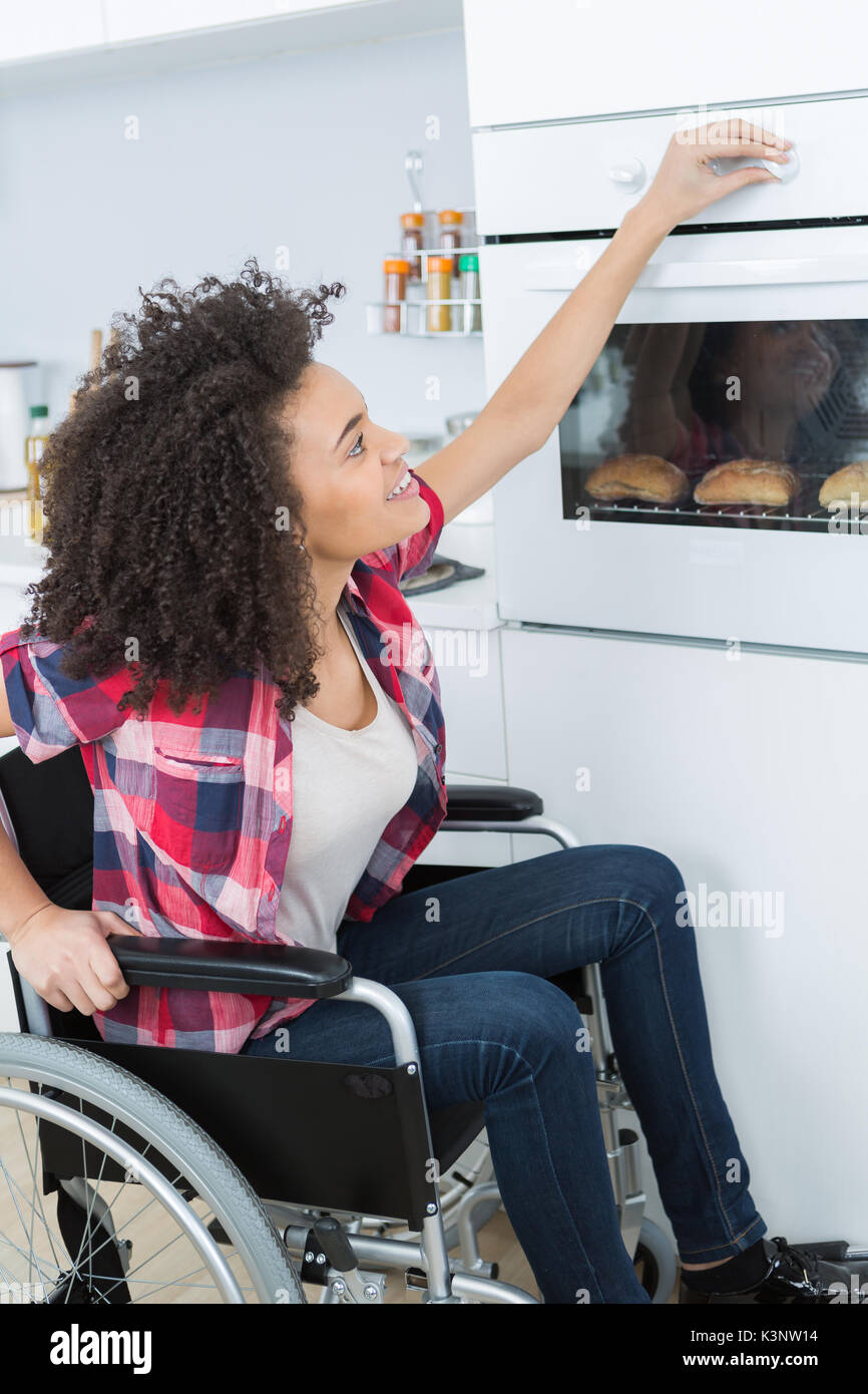 disabled young woman in wheelchair opens the oven Stock Photo - Alamy