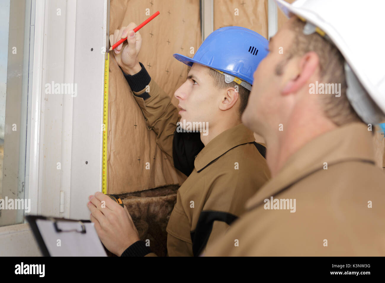 builder and architect working together measuring wall Stock Photo - Alamy