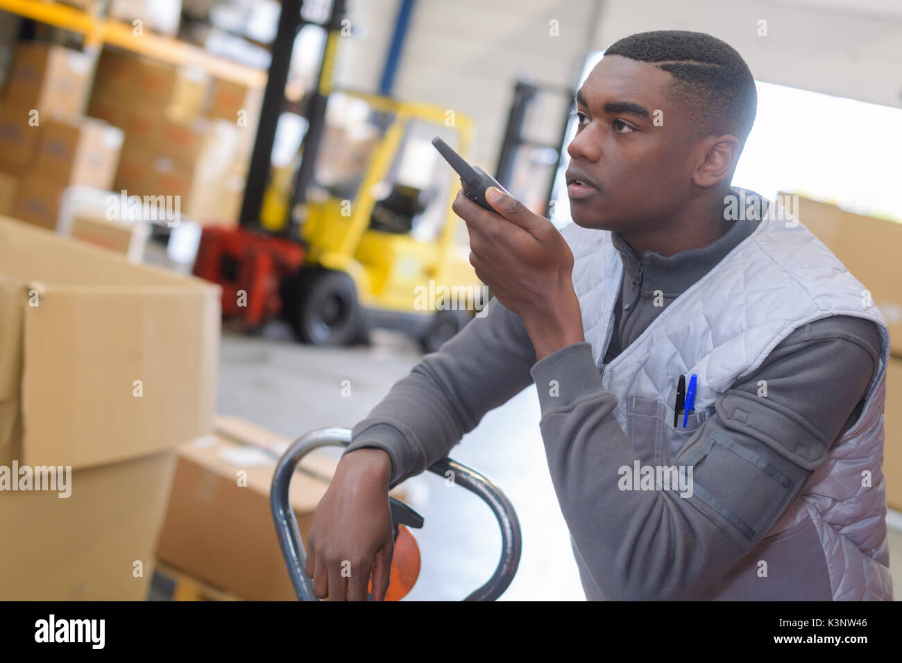 worker using phone in warehouse Stock Photo - Alamy