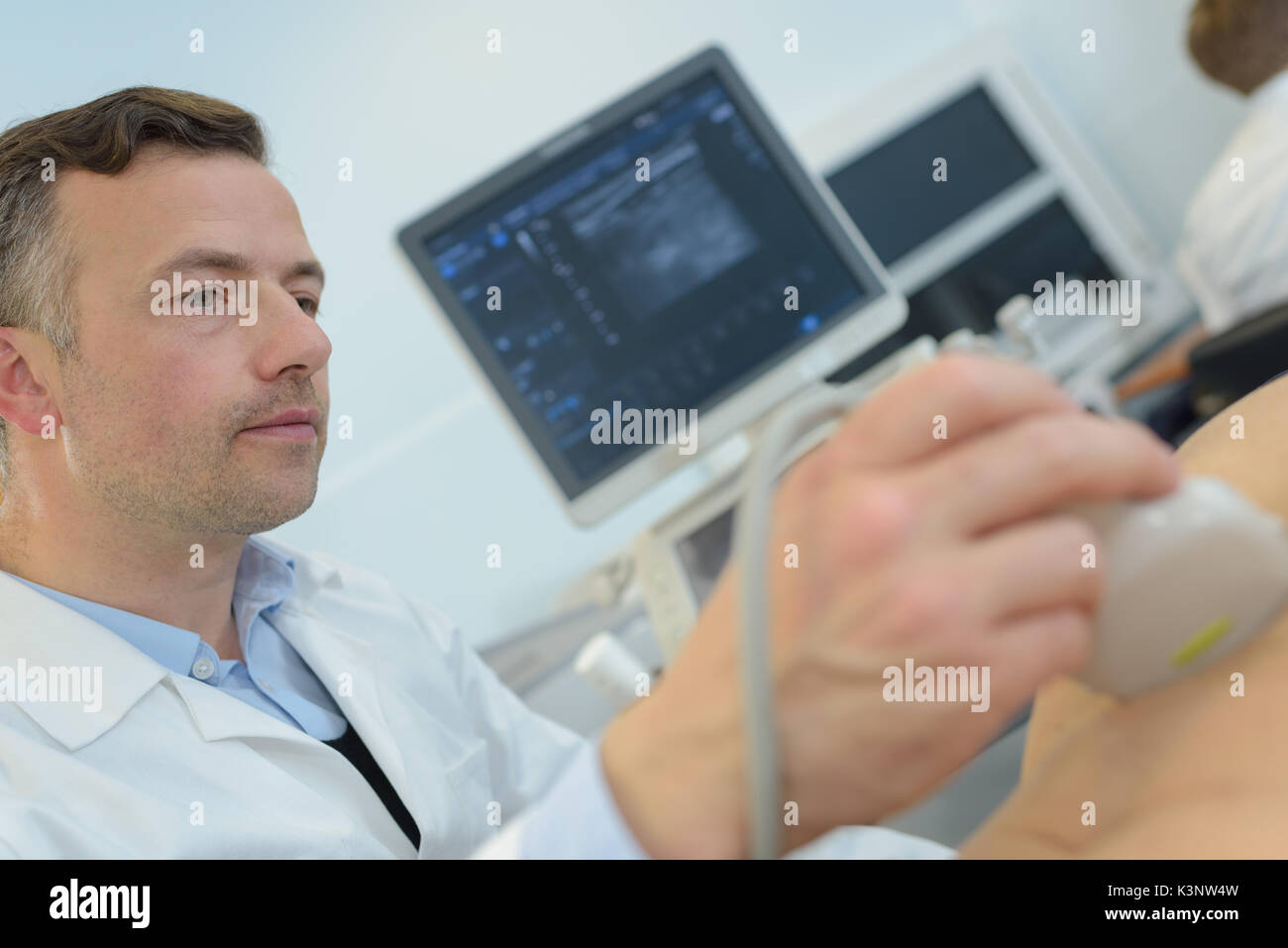 doctor with patient undergoing arm echography Stock Photo - Alamy