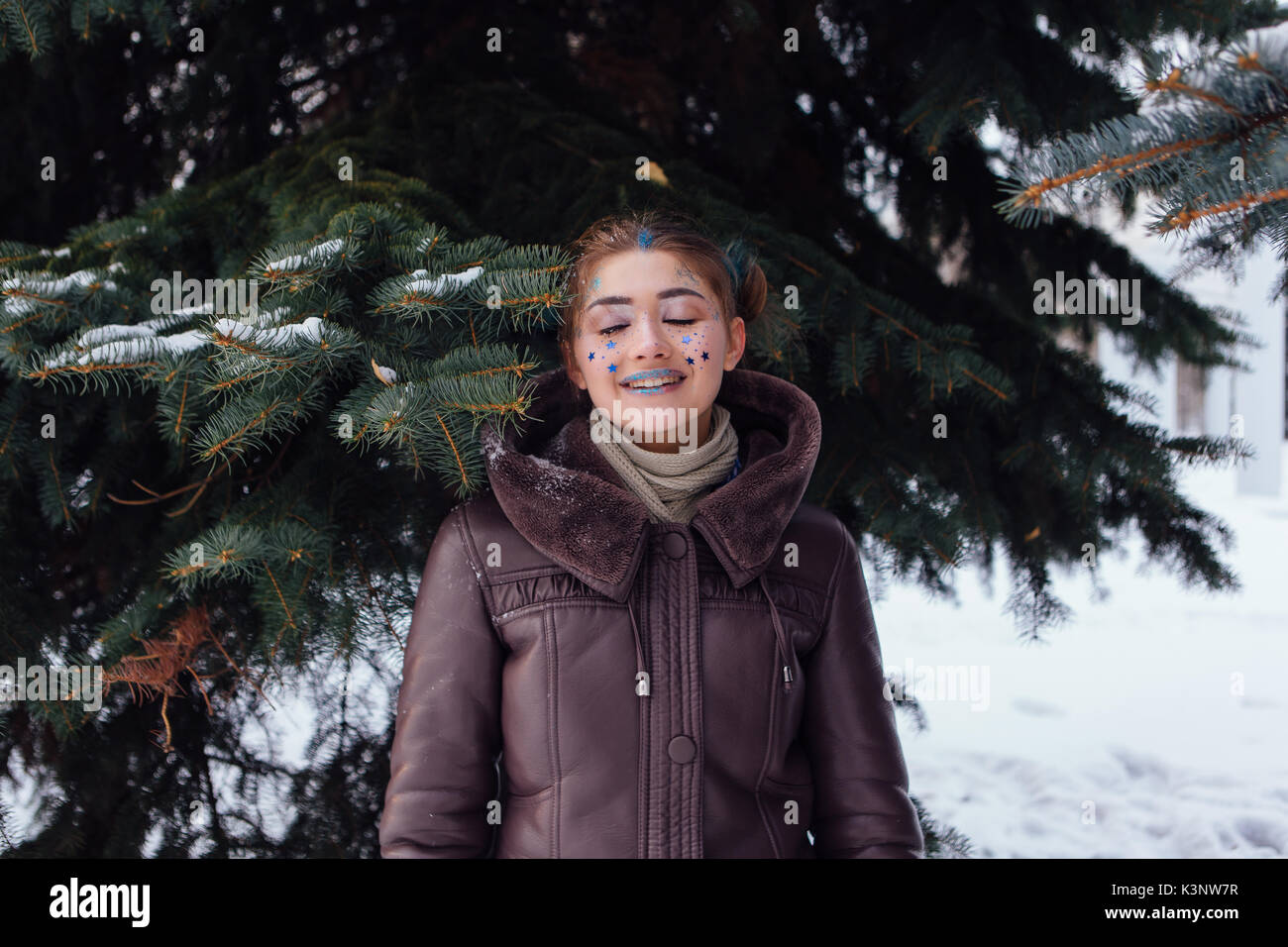 Winter portrait of a girl with bright make up and blue stars on face ...
