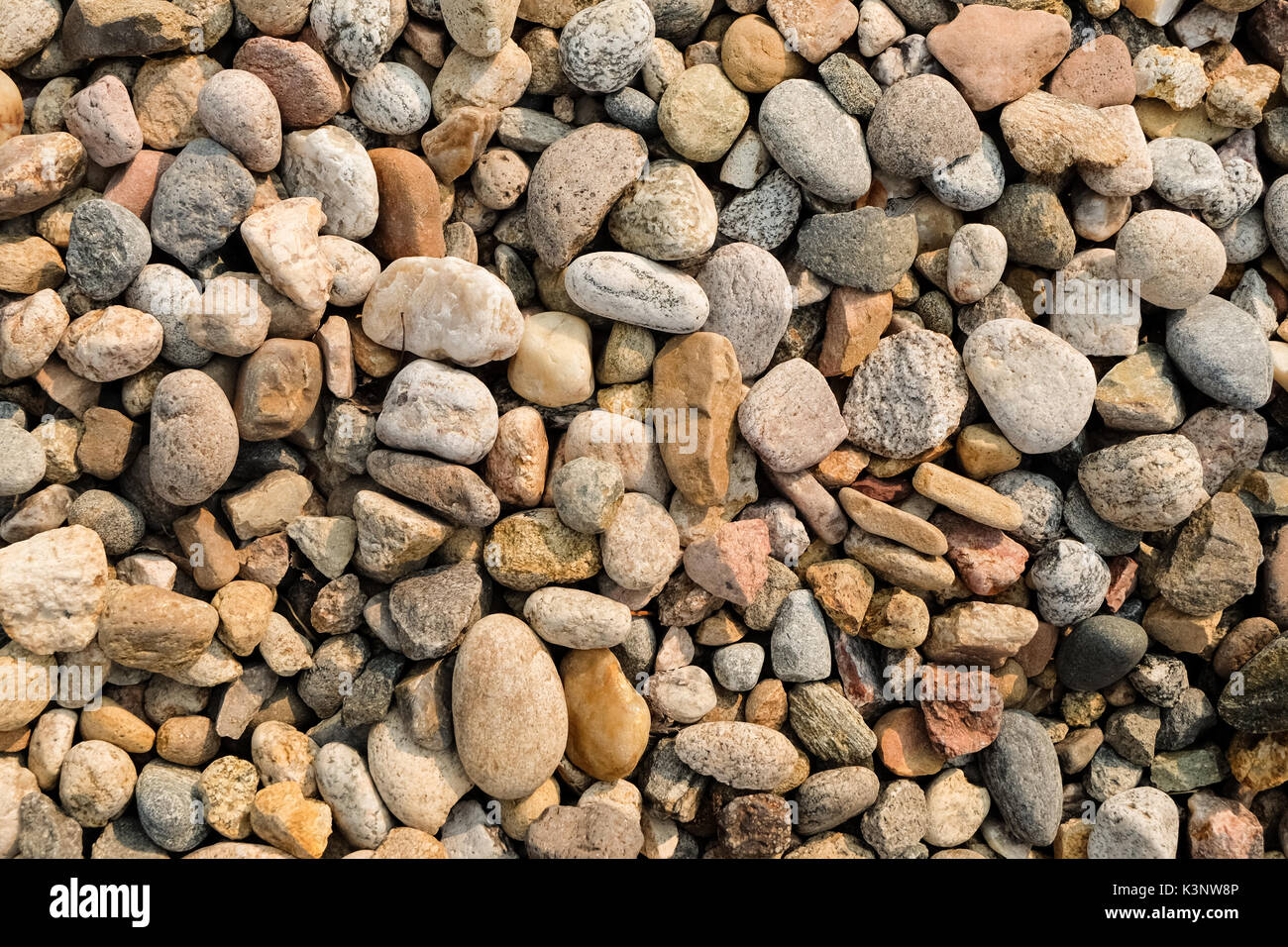 Close up of rounded and polished beach rocks background Stock Photo - Alamy