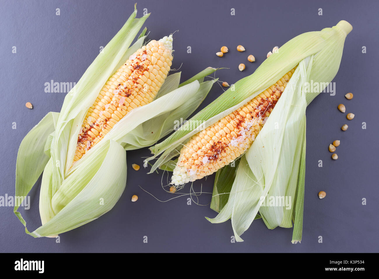 Two cobs of corn, raw in husks Stock Photo - Alamy