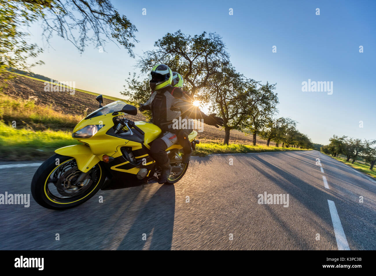 Motorbikers on sports motorbike riding in sunset. Outdoor photography ...