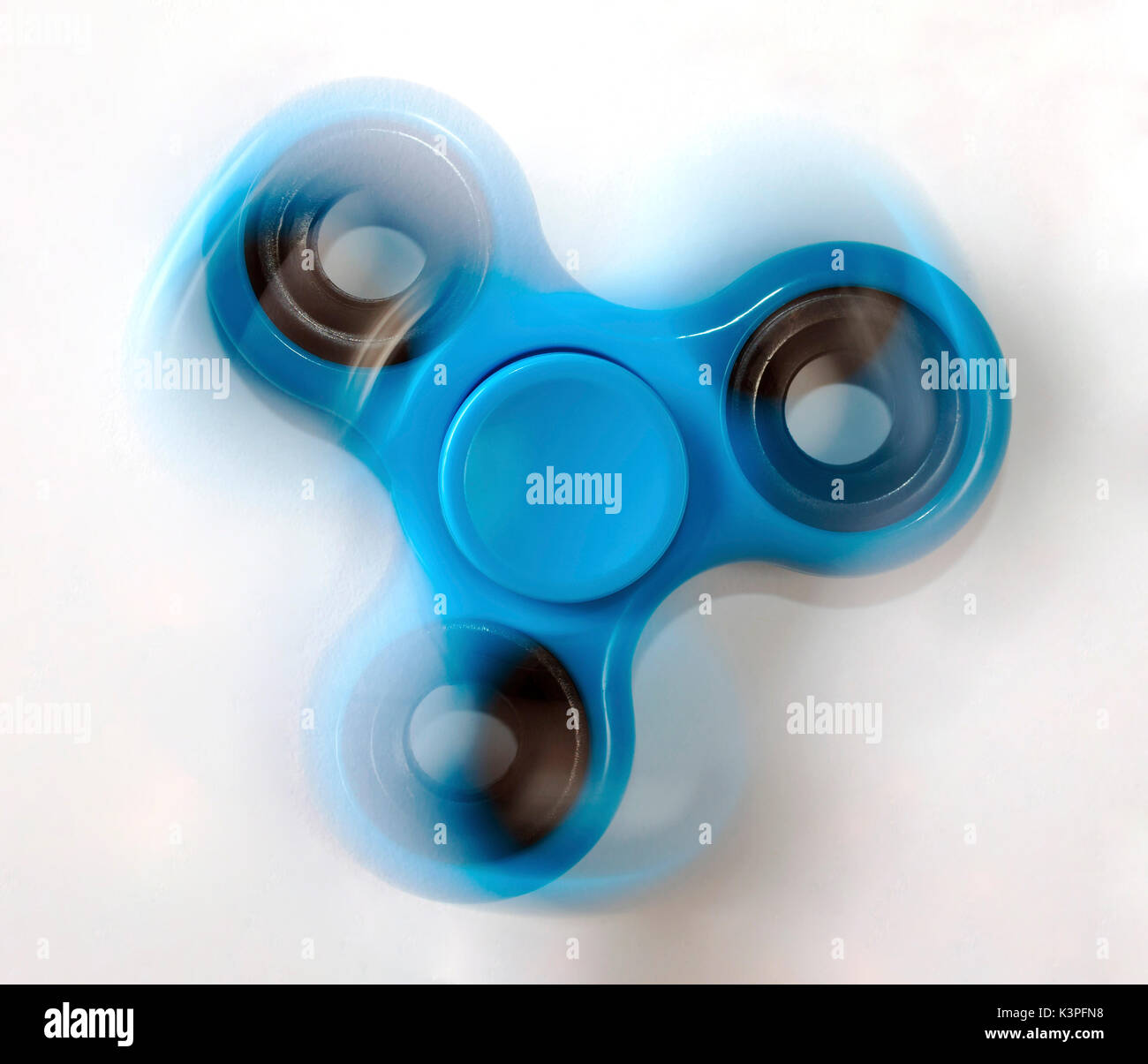 Finger spinner made of blue plastic showing motion blur as it spins on ...