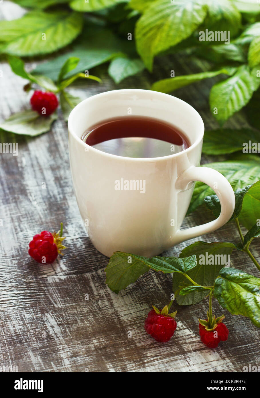 Tea with raspberries and raspberries on a wooden background. Place ...