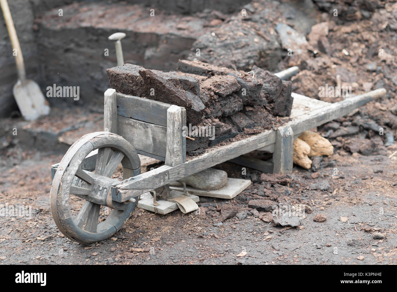 Old original wooden wheelbarrow for transporting stabbed peat blocks in ...