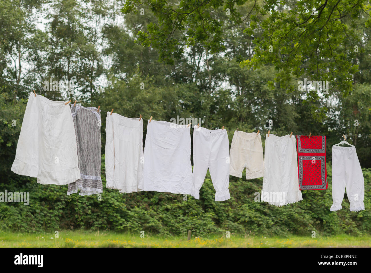 Old-fashioned clothesline with authentic clothes from the last century ...