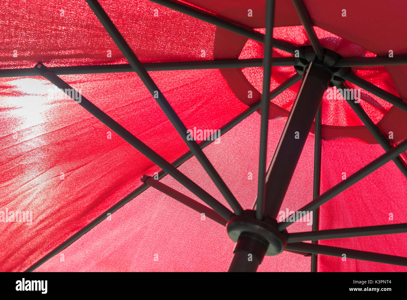 Red parasol with the sun translucent by the canvas Stock Photo - Alamy