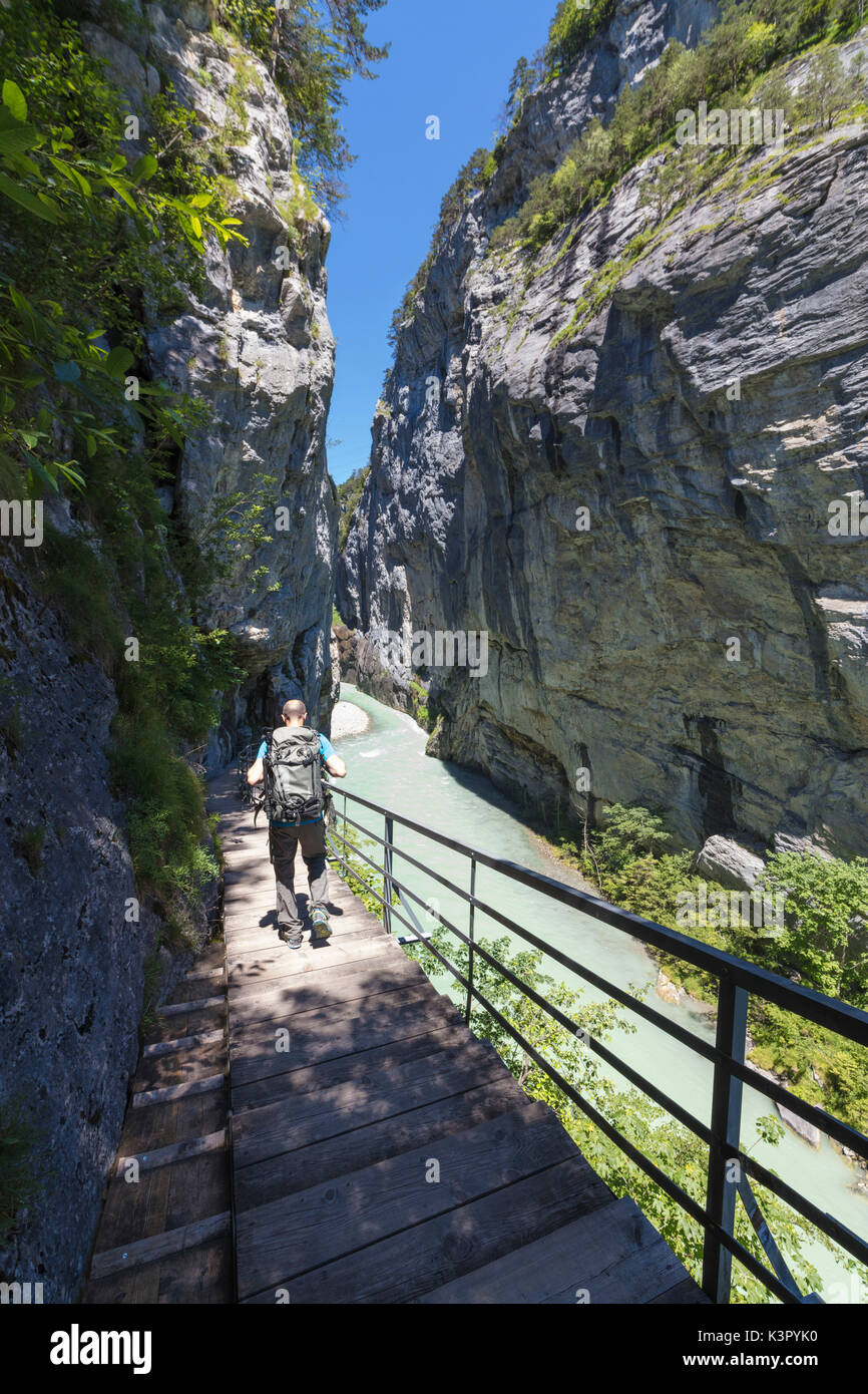 Hiker on the safety walkway on creek through the limestone gorge Aare ...