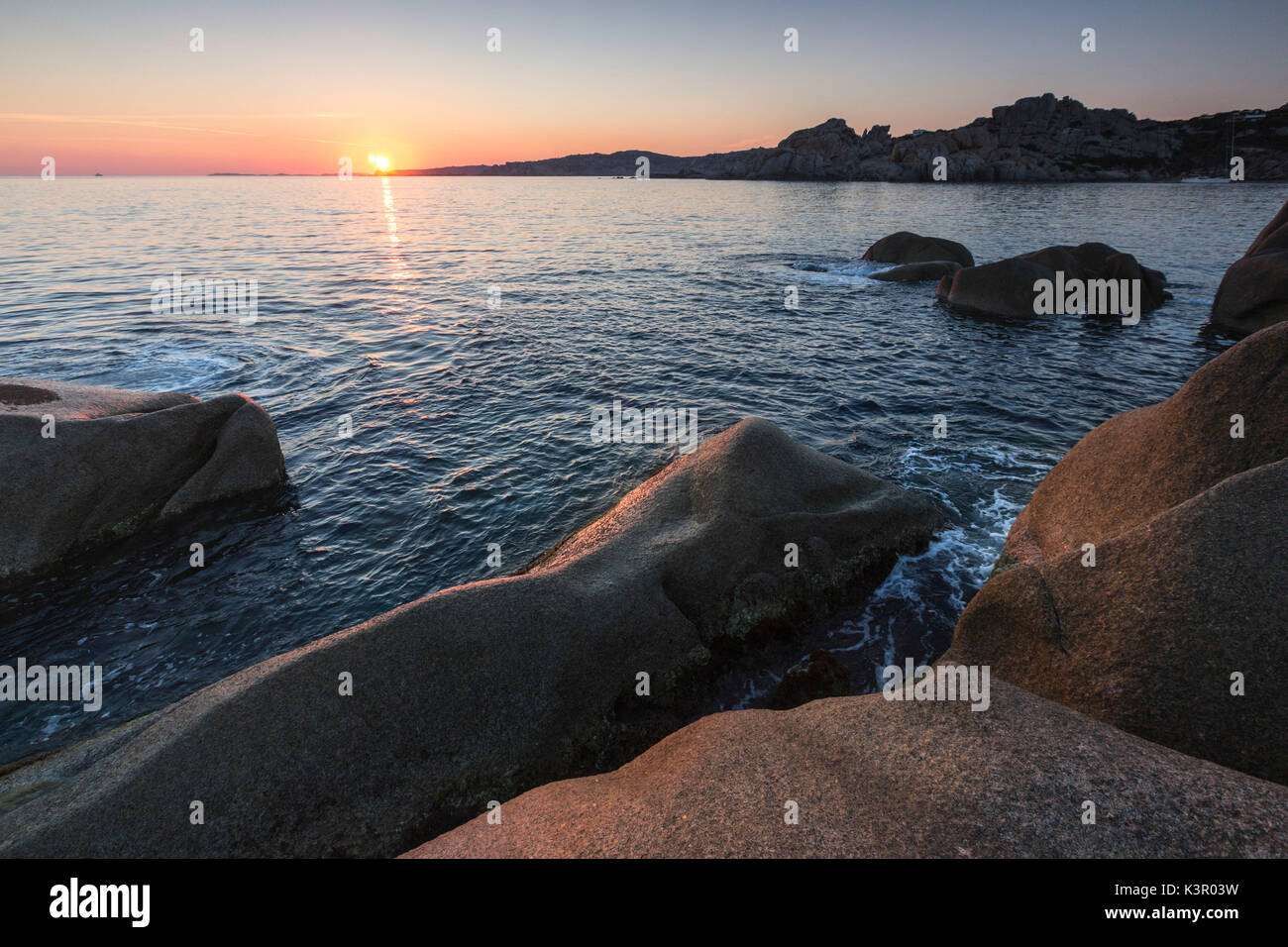 Sunset on modeled cliffs by wind framing blue sea Capo Testa Santa ...